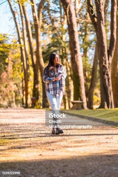 가을 라이프 스타일 젊은 백인 갈색 머리 소녀 에 A 격자 무늬 울 스웨터와 찢어진 청바지 에 A 공원 10월에 대한 스톡 사진