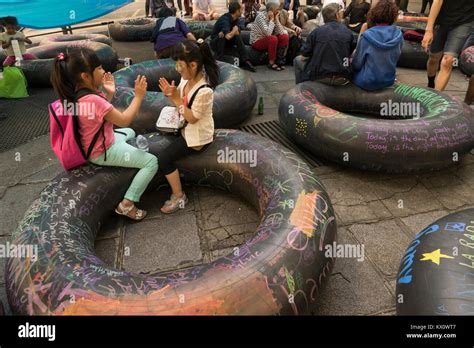 Two Asian Girls Playing Patty Cake On Inner Tube Paris France Stock