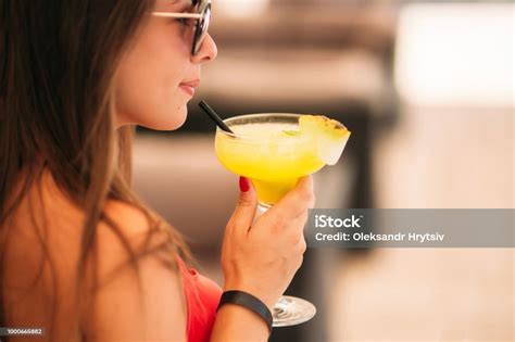 비치 클럽 바의 오두막에 앉아 화려한 칵테일을 마시는 수영복을 입고 아름 다운 젊은 여자 여름 시간에 그녀의 음료를 즐기는 멋진 여자 귀여운에 대한 스톡 사진 및 기타