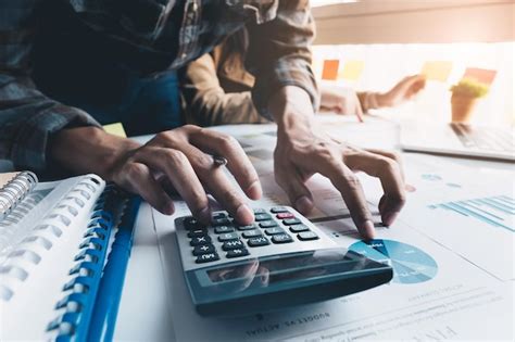 premium photo midsection of businessman calculating data on desk at
