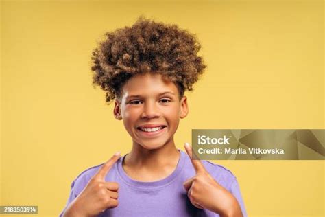 곱슬 머리를 가진 매력적이고 웃는 아프리카 계 미국인 소년이 이빨에 손가락을 가리키고 카메라를 보고 있습니다 8 9 살에 대한 스톡 사진 및 기타 이미지 Istock