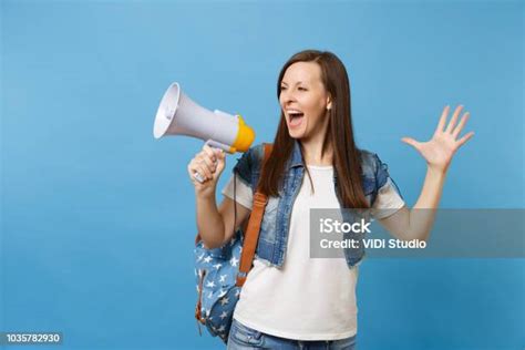 배낭 데님 옷에서 젊은 감정적인 여자 학생의 확성기 파란색 배경에 고립 확산 손에 비명 개최 고등학교에서 교육입니다 광고에 대 한 공간을 복사 합니다 20 29세에 대한