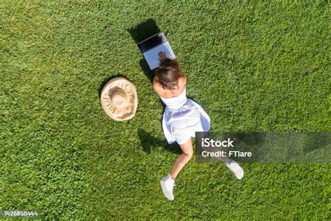 하얀 드레스를 입은 여성 노트북이 달린 모자 여름날 푸른 잔디밭에 누워있는 여성 상단보기 무인 항공기 조감도 35 39세에 대한 스톡 사진 및 기타 이미지 Istock