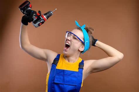 Premium Photo Female Construction Worker Yawns With A Tool In Her Hands Studio Shot