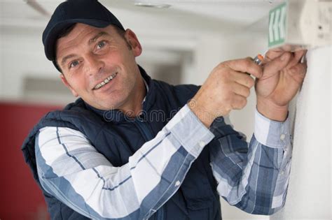 Man Fixing Exit Sign To Wall Stock Photo Image Of Direction Sign