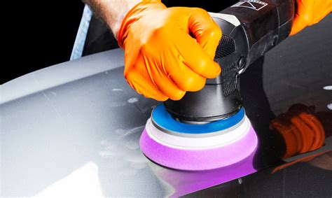 광택을 내기 전에 보호 테이프를 적용 하는 자동차 폴란드어 왁 스 노동자 손 버프 및 연마 자동차 자동차 세부 남자는 손에 폴 리 셔를 보유 하 고 차를 연마 연마 용 공구