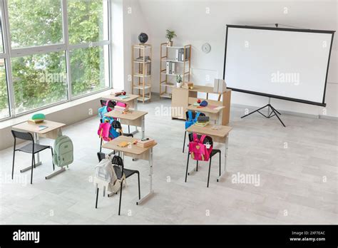 Interior Of Light Classroom With Projector Screen And Desks Stock Photo Alamy
