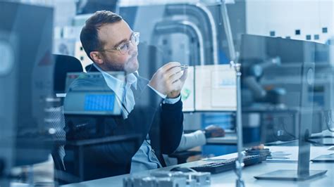 전자 공장 남성 전기 엔지니어는 Pcb 프로토타입을 보유하고 개인용 컴퓨터에서 작동하며 마이크로칩 반도체 및 통신 장비를 개발합니다 제조 시설 반도체에 대한 스톡 사진 및