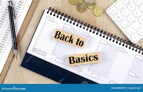 Back To Basics Word Written On Wooden Block On Planner With Coins Clipboard And Calculator