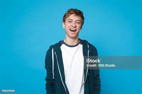 스튜디오에서 파란색 벽 배경에 고립 된 캐주얼 옷에 웃 고 잘 생긴 젊은 남자의 초상화 사람들은 진심으로 감정 라이프 스타일 개념입니다 복사 공간을 모의 합니다 광고 영역