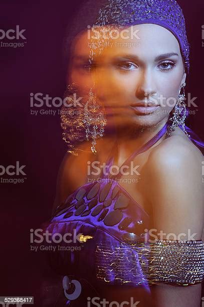 สาวในชุดสีม่วงและเครื่องประดับที่สวยงามในการเคลื่อนไหวเบลอ ภาพสต็อก