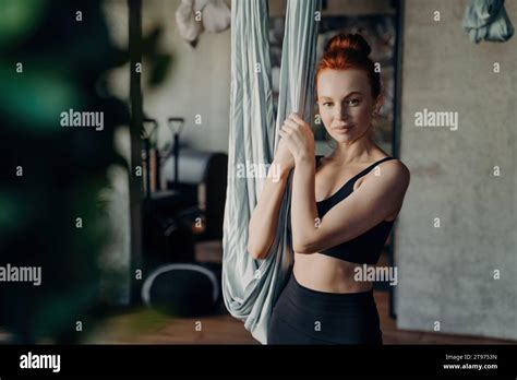 Fit Redhead Woman In Sportswear Posing With Aerial Silk In A Gym