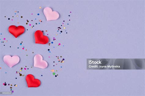복사 공간이있는 발렌타인 데이 축제 배경 트렌디 한 보라색 배경에 여러 가지 색의 색종이가있는 분홍색과 빨간색 하트 플랫 레이 상단보기 인사말 카드 및 초대장 템플릿