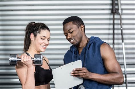 Premium Photo Athletic Trainer Explaining Workout Plan To Woman At Crossfit Gym