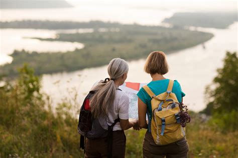 배낭을 든 두 명의 중년 여성 친구는 산에 서서 자연에서 하이킹을하고지도를보고 함께 시간을 보냅니다 여행 관광 개념 주말에는 야외 활동 미소에 대한 스톡 사진 및 기타
