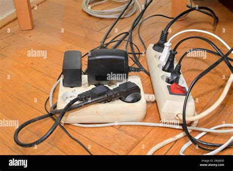 Tangled Cables On The Parquet Floor Overloaded Electrical Boards On The Wooden Floor