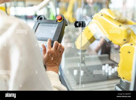 Woman In Factory Using Control Of Industrial Robot Stock Photo Alamy