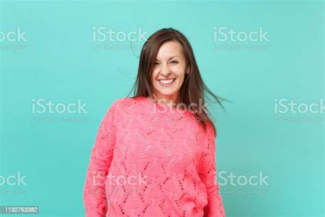 파란색 청록색 벽 배경 스튜디오 초상화에 고립 된 머리를 끼고 있는 니트 핑크 스웨터에 웃는 멋진 젊은 여자 사람들은 진심으로 감정 라이프 스타일 개념입니다 복사 공간을