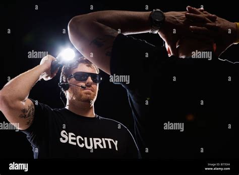 Security Guard Shining Flashlight On Man Stock Photo Alamy