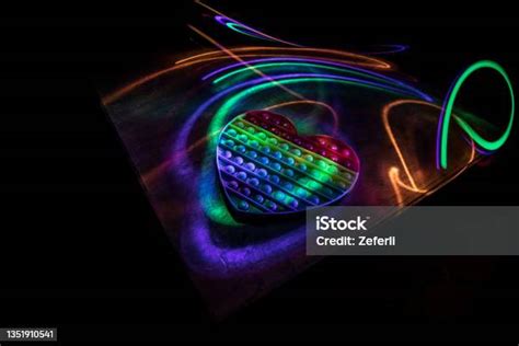 아이들은 안티 스트레스 감각이 검은 테이블이나 바닥 배경에 장난감을 밀어 또는 간단한 보조개 안절부절 팝 팝 무지개 색조 밝은