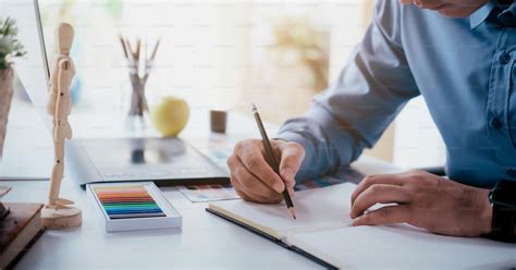 디자이너가 뭔가를 스케치합니다 사무실에서 일하는 젊은 사진 작가이자 그래픽 디자이너 사진 Unsplash의 테이블 이미지