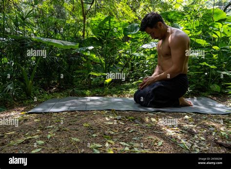 Young Latin Man Arranging His Yoga Mat Inside A Forest On A Plain