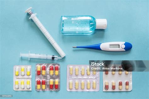 바이러스 예방 및 치료 마스크 착용 손 소독 항 바이러스 약물 및 비타민 복용 파란색 배경에 의약품이있는 응급 처치 키트 0명에