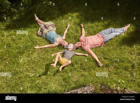 Mother Father And Son In Garden Lying On Grass Relaxing Stock Photo Alamy