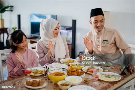 하리 라야 에딜피트리 축하를 위해 친구와 가족을 부르는 전통 의류 영상에 있는 말레이 무슬림 가족 가족에 대한 스톡 사진 및 기타 이미지 Istock