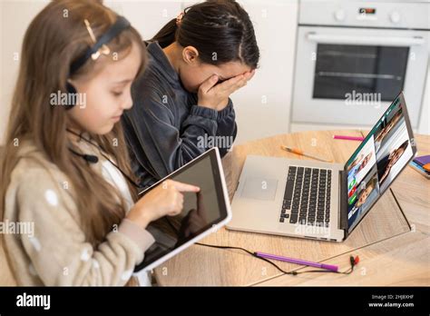 Pretty Teen Girl Point To Laptop Screen And Her Younger Sister Look
