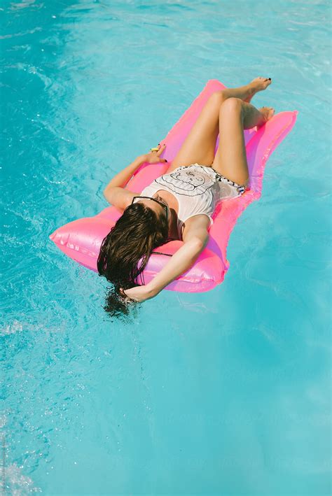 Brunette Woman Relaxing On The Floating Bed In The Swimming Pool By