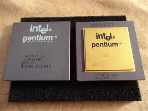 Two Intel Cpus Sitting On Top Of Each Other Next To A Black And Gold Box
