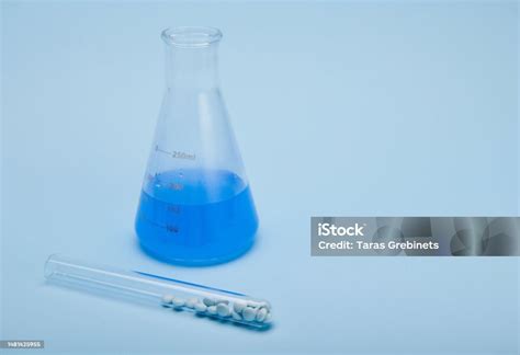 파란색으로 분리된 시험관 내부에 파란색 유체 화학 용액과 과립이 있는 눈금이 매겨진 평평한 바닥 실험실 플라스크 0명에 대한