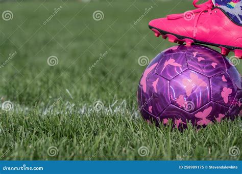 Selective Focus On Girls Soccer Ball With A Player On The Grass Field