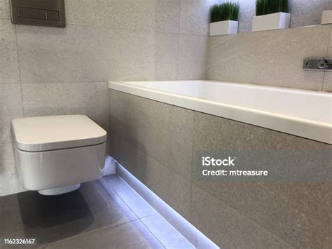 현대 광장 벽 매달려 화장실 팬 화장실 벽에 걸려 현대 흰색 럭셔리 욕실 스위트의 이미지 큰 베이지 색 돌 화강암 벽 타일과 타일 바닥 욕조 주각 방수 Led 조명과 탭싱크