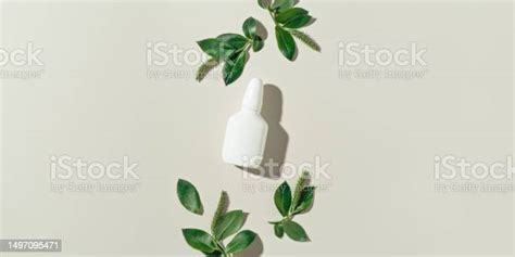 계절 알레르기 개념 봄의 어린 나뭇가지에 새로운 녹색 잎과 캣킨이 있는 나무 베이지색 배경에 흰색 비강 스프레이 최소한의