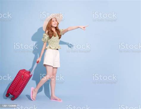 파란색 배경에 여행 가방을 가진 젊은 아시아 소녀의 전체 길이 이미지 여행 컨셉 여행 가방에 대한 스톡 사진 및 기타 이미지 여행 가방 한 명의 여자만 가리키기