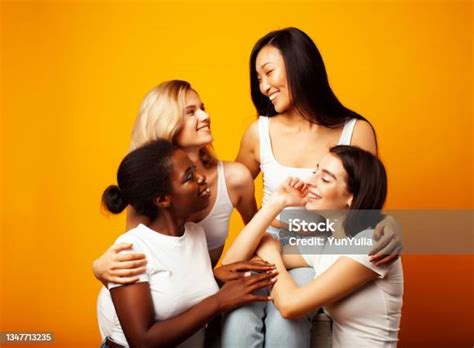 다양한 다국적 걸그룹 십대 친구 회사 명랑 재미 행복한 미소 노란 배경에 귀여운 포즈 라이프 스타일 사람들 개념 아프리카 계 미국인 아시아와 백인 개성 개념에 대한 스톡