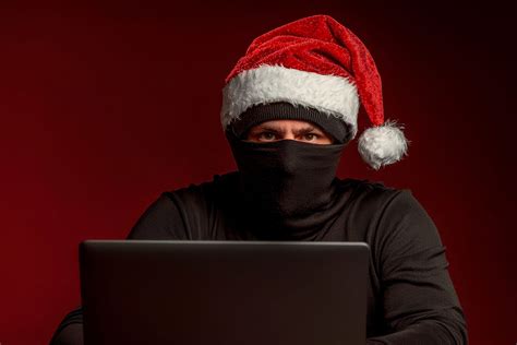 Santa Hacker Holding Laptop Computer Anonymous Man On Black Background