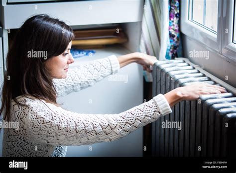 Woman Adjusting A Thermostatic Radiator Valve On A Domestic Radiator Stock Photo Alamy