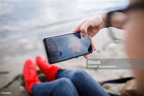 소식통 여자 들고 스마트폰 야외입니다 피트 Selfie를 복용 하는 젊은 여자 다리 신체 부분에 대한 스톡 사진 및 기타 이미지 다리 신체 부분 모던 양식 무선 기술