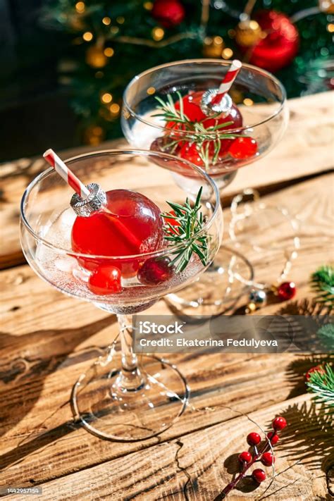 크리스마스 다과 음료 미모사 펀치 또는 크랜베리 마가리타 칵테일은 크리스마스 장식품과 마티니 마시는 안경에 제공됩니다