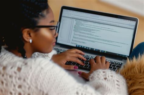 Young Woman Programming On A Laptop At Home Beautiful Young Black Woman Programming On A Laptop