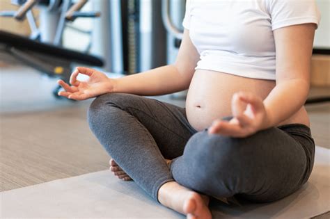 요가룸의 피트니스 센터에서 활동적인 임산부 운동을 합니다 임신 한 배에 아기를 들고 젊은 기대 어머니 출산 전 관리 및 여성 임신 개념 건강한 생활방식에 대한 스톡 사진 및