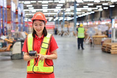 안전모와 반사 재킷을 입은 창고 노동자 여성들은 스캐너 바코드를 들고 생산 재고와 소매 창고 물류 센터 배경이 있는 카메라를 보고 있다 30 34세에 대한 스톡 사진 및