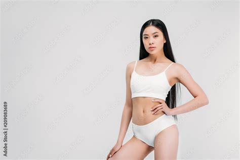 Beautiful Asian Girl Posing In White Panties And Bra Isolated On Grey