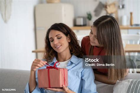 귀여운 십 대 소녀 딸은 집에서 생일을 가진 행복한 젊은 어머니를 축하하고 그녀의 선물 상자를 준다 선물에 대한 스톡 사진 및 기타 이미지 Istock