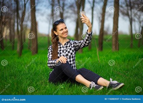 Pretty Woman Resting In Park And Take Selfie On Phone Stock Image