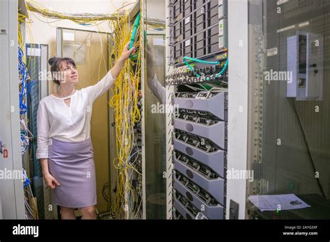 Woman Checks The Connection Of The Internet Optical Wires In The Server Room Of The Data Center