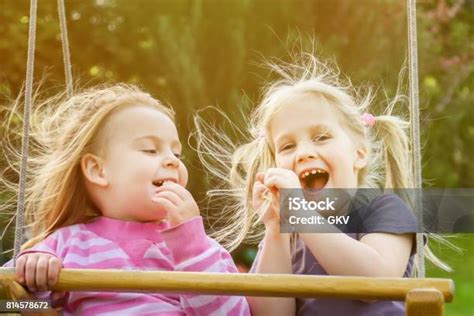두 명의 귀여운 작은 소녀 재미 스윙에 아름 다운 여름 정원 주변 인물 소프트 포커스에서 함께 귀여운에 대한 스톡 사진 및 기타